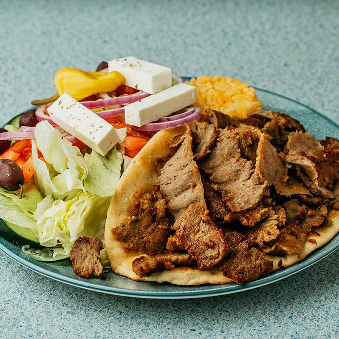A Greek platter that would make Zeus himself nod in approval &ndash; tender gyro meat, fresh salad, and a side that completes the Mediterranean journey.