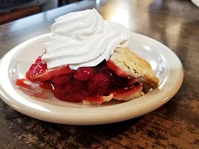 Blueberry pie that looks like it walked out of a Norman Rockwell painting, complete with whipped cream clouds that slowly melt into warm, jammy filling.