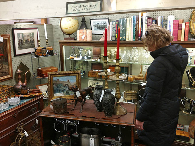A shopper examines delicate treasures at "English Treasures" booth, where every item tells a story spanning continents and centuries.