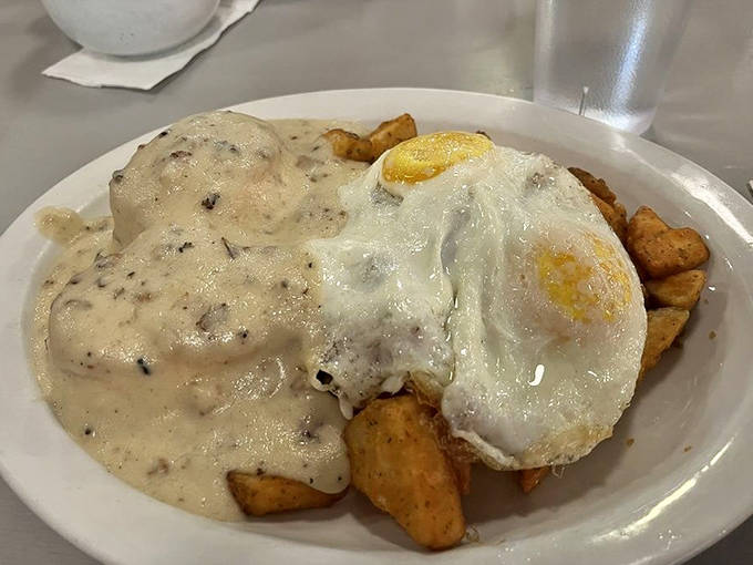 Biscuits and gravy reimagined &ndash; a golden throne of potatoes crowned with creamy sausage gravy and a perfectly fried egg. Comfort food that hugs your soul.