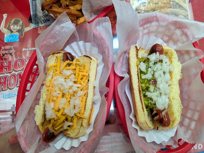 These aren't just hot dogs&mdash;they're edible art. One loaded with cheese and onions, the other with relish and onions, both begging to be devoured.