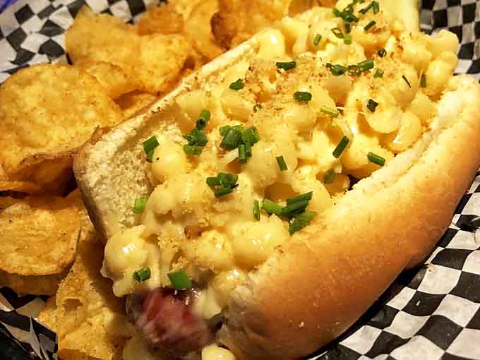 The Mac & Cheese Dog defies gravity and good sense &ndash; creamy mac atop a juicy dog creates a comfort food masterpiece.