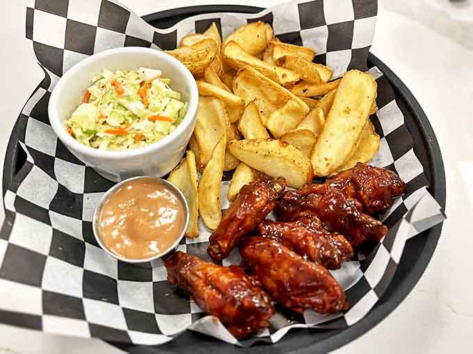 Buffalo chicken bites with golden fries and creamy slaw &ndash; comfort food that speaks a universal language of satisfaction.