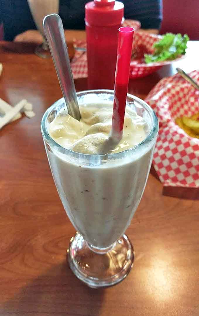 This lime shake isn't just a drink, it's a creamy green revelation topped with a cloud of whipped cream and that perfect cherry exclamation point.
