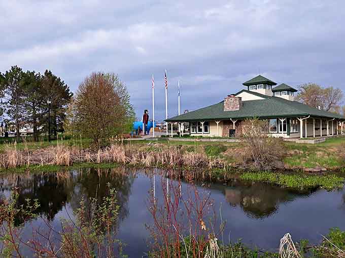 The serene pond reflects Bemidji's visitor center, creating a postcard-perfect scene that would make even Paul Bunyan pause his logging.