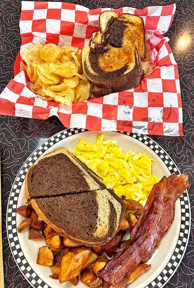 Marbled rye cradles a hearty breakfast sandwich while golden home fries and fluffy eggs stand ready to fuel your day with comfort and satisfaction.