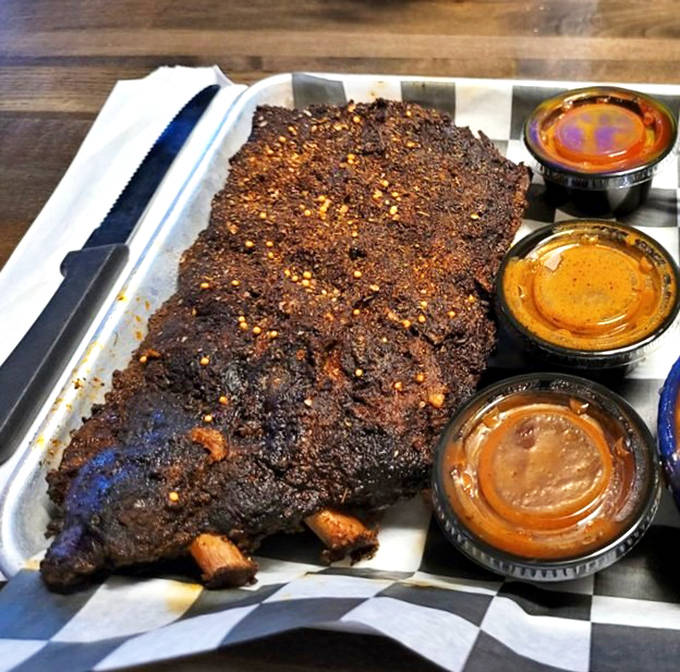 These ribs aren't just cooked, they're coaxed to perfection. That bark! That smoke ring! Those sauces waiting patiently for their moment!