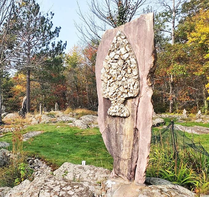 This striking monolith features a meticulously crafted arrowhead mosaic, demonstrating the painstaking detail work that makes these gardens more than just piled rocks.