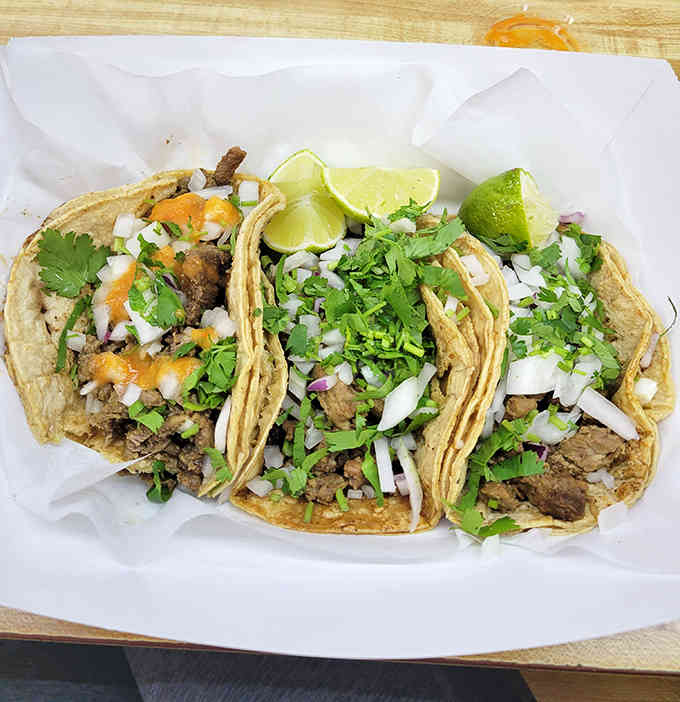 Taco perfection on display: tender meat nestled in fresh corn tortillas, topped with nothing but cilantro, onion, and lime &ndash; simplicity at its most delicious.