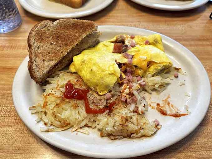 Golden eggs nestled against crispy hash browns with perfectly cooked ham bits &ndash; breakfast doesn't get more satisfying than this.