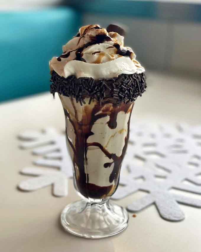 This isn't just a milkshake &ndash; it's a chocolate masterpiece with whipped cream peaks, chocolate drizzle rivers, and sprinkles that would make Willy Wonka jealous.