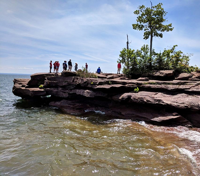 Adventurers perched on ancient red rocks, where Lake Superior has been sculpting masterpieces for thousands of years.
