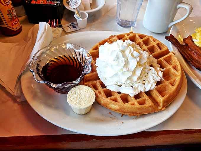 This golden waffle topped with a cloud of whipped cream isn't just breakfast &ndash; it's a fluffy canvas for maple syrup masterpieces.