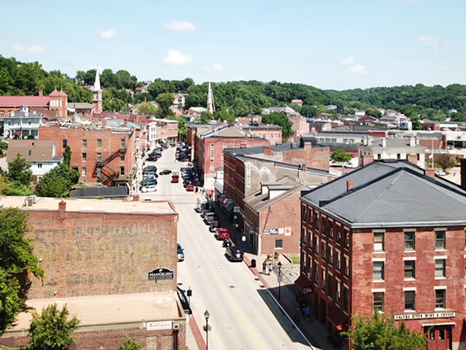 Galena unfolds like a miniature model village nestled among rolling hills, its red-brick heart visible from this bird's-eye perspective.