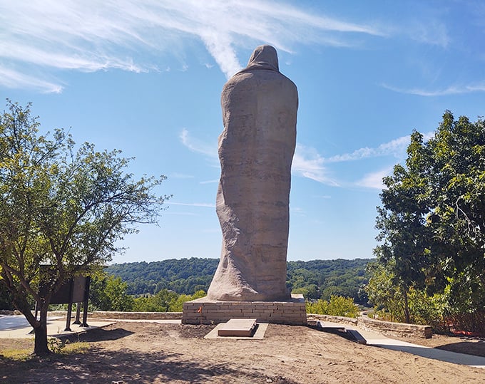 From behind, the statue's imposing silhouette creates a striking contrast against the clear blue sky &ndash; concrete poetry in three dimensions.