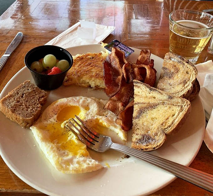 Breakfast platters arrive with perfectly cooked eggs, crispy bacon, and golden toast – somehow tasting even better when eaten inside a caboose.