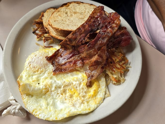 Breakfast perfection on a plate &ndash; those sunny-side up eggs, crispy bacon, and hash browns are the holy trinity of morning bliss.
