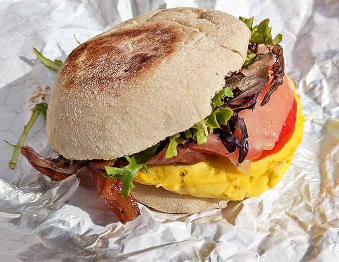 This isn't just a breakfast sandwich &ndash; it's a masterpiece of morning engineering with perfectly cooked egg, crisp bacon, and fresh greens on housemade bread.