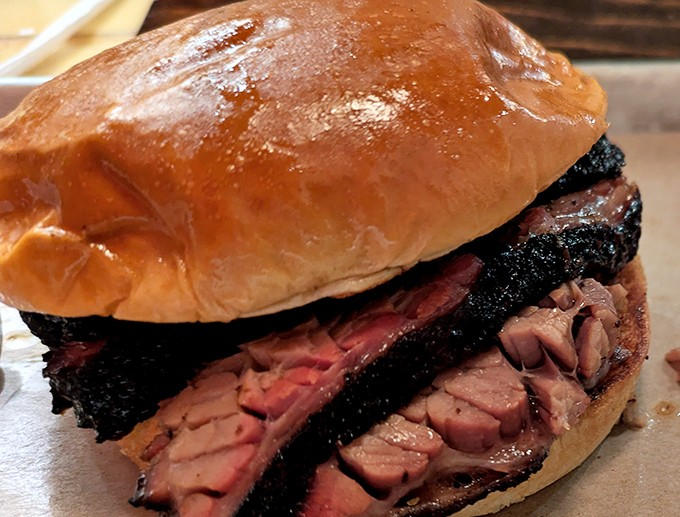 This isn't just a sandwich &ndash; it's a masterpiece of smoke and patience, where perfectly barked brisket meets its humble bread companion.