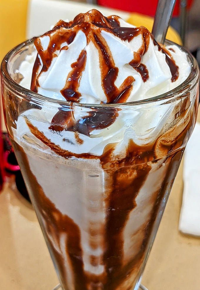 This chocolate milkshake isn't just a drink, it's a towering monument to dairy perfection, crowned with whipped cream and chocolate drizzle.