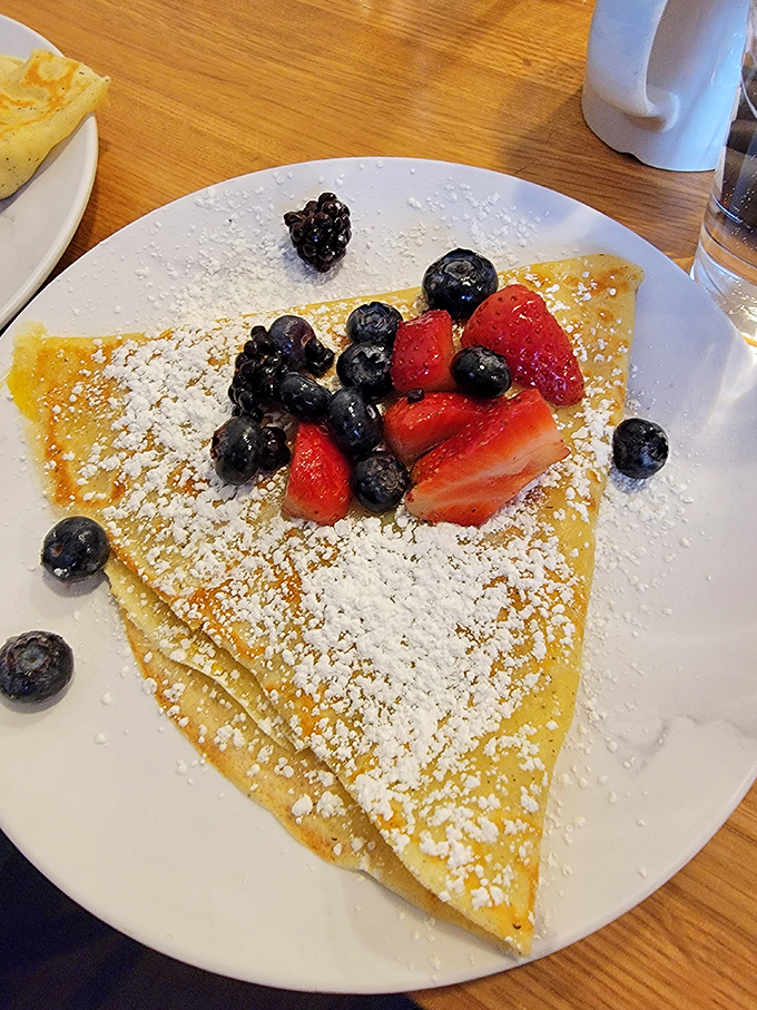 This isn't just breakfast, it's edible artwork &ndash; a paper-thin crepe cradling fresh berries and dusted with powdered sugar snow.