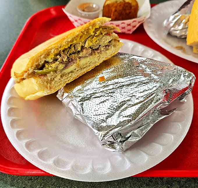 This isn't just lunch, it's edible architecture &ndash; layers of roasted pork, ham, and Swiss cheese creating the perfect sandwich skyline.