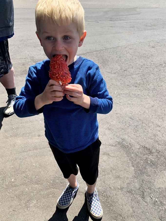 Pure joy captured: A young customer tackles a cherry-topped ice cream treat with the serious concentration only kids can muster. 