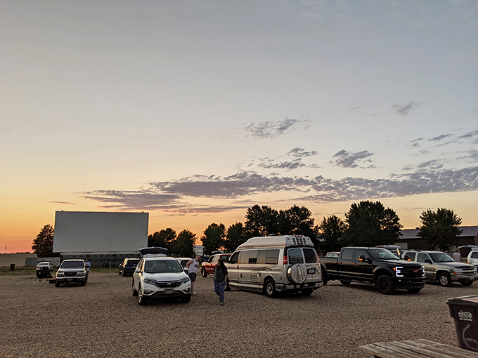 Cars gather in anticipation as the sun sets, each vehicle a private living room with the best view in town.