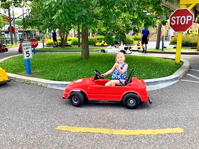 Future drivers navigate the mini roadways with surprising focus, some obeying traffic rules better than their parents do on actual highways.