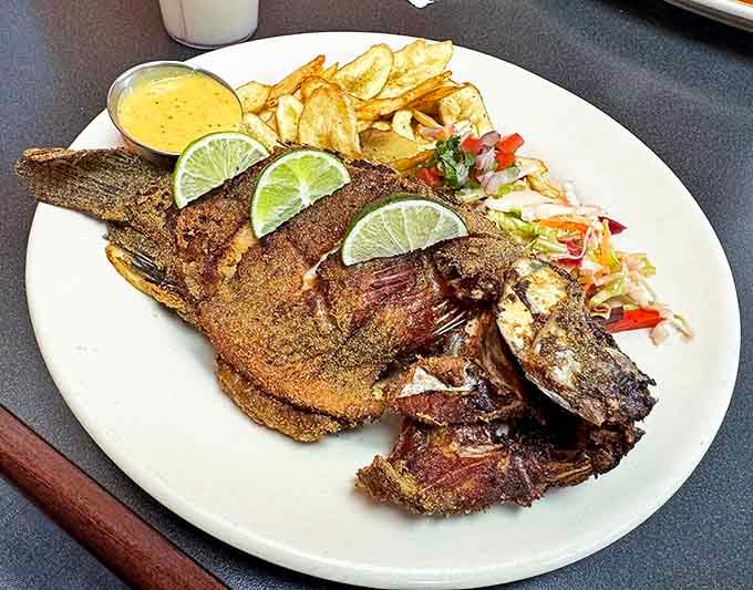 This isn't just fried fish &ndash; it's Pescado Frito, a crispy-outside, tender-inside masterpiece garnished with lime wedges that brighten every bite.