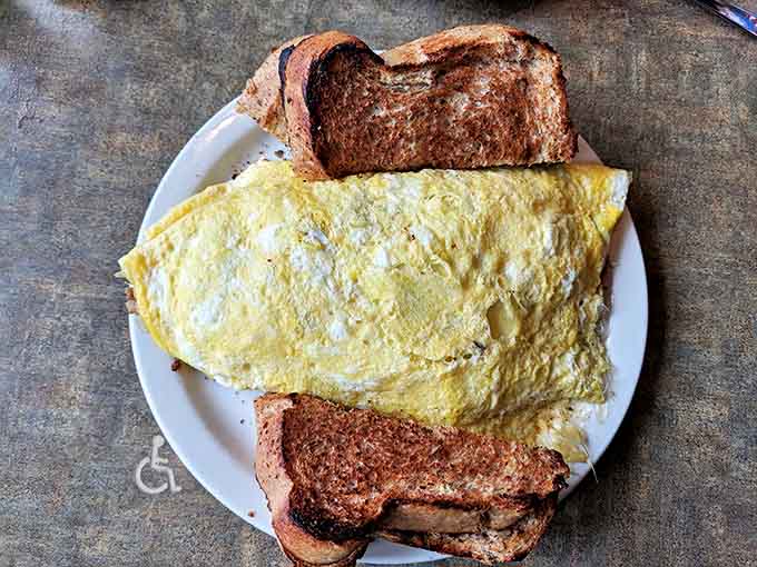 This isn't just an omelet &ndash; it's a golden envelope of egg perfection, delivering joy with every bite alongside perfectly toasted bread companions.