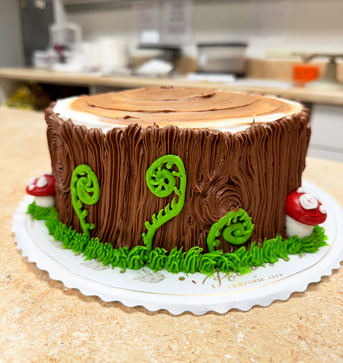 Someone turned a tree stump into a chocolate masterpiece complete with mushrooms and ferns, proving that cake decorators here have skills that border on actual wizardry.