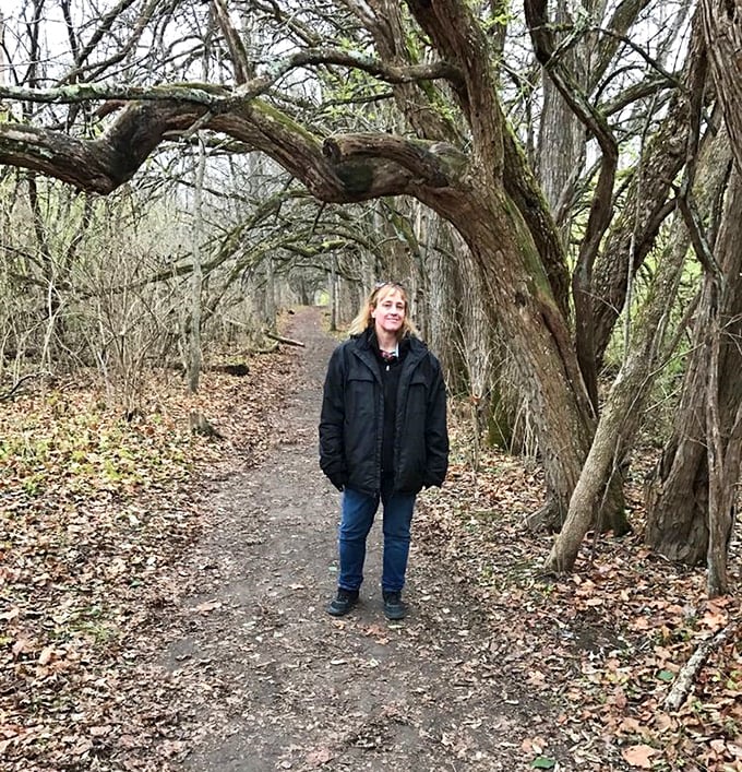 A visitor pauses to soak in the tunnel's magic during autumn – when even the most hurried souls find themselves slowing down to appreciate nature's artistry.