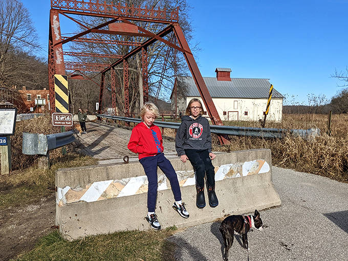 Young explorers perch on a concrete barrier, proving history can compete with video games when presented in the great outdoors.