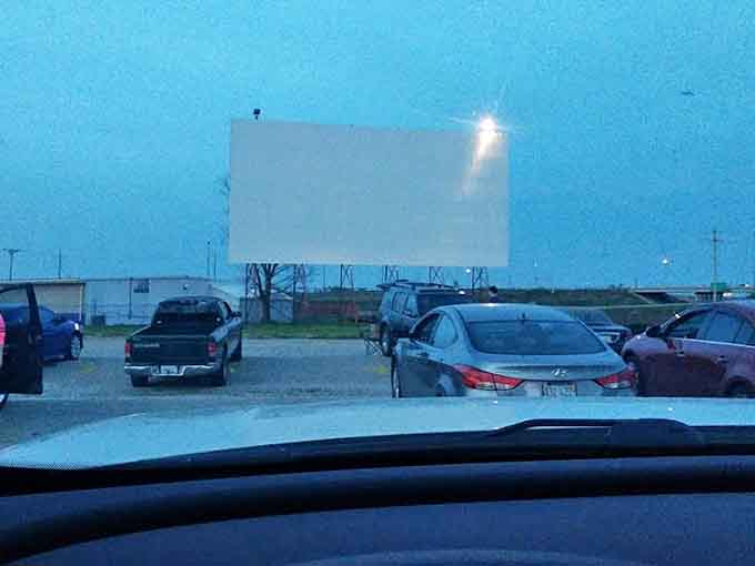 The massive white screen stands ready for showtime, a blank canvas awaiting the stories that will transport audiences to different worlds.
