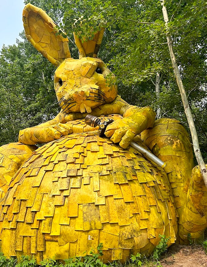 The golden rabbit sits in contemplative splendor, its recycled wooden form glowing like treasure in the forest light.