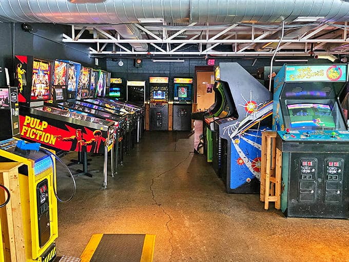 Row after glorious row of arcade cabinets stand at attention, their screens glowing with the promise of pixelated glory.