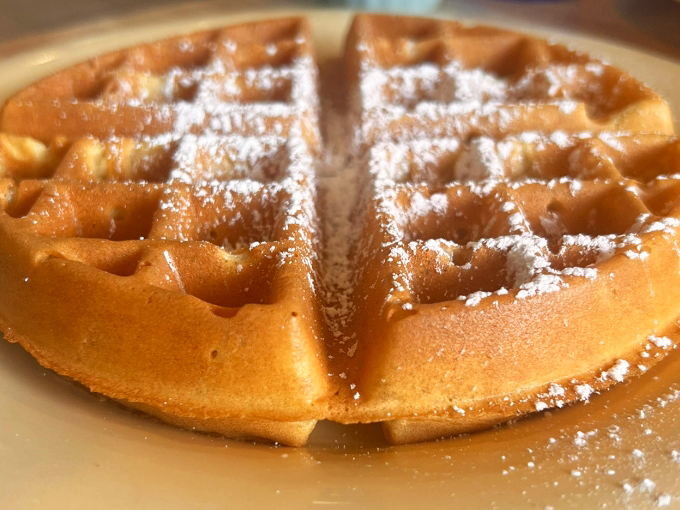 This Belgian waffle doesn't need a passport to impress – golden, crisp exterior giving way to a fluffy interior that's practically begging for maple syrup.