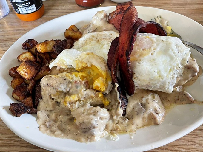 The perfect breakfast trifecta: crispy home fries, eggs smothered in that legendary gravy, and bacon that's achieved the ideal crisp-to-chewy ratio.