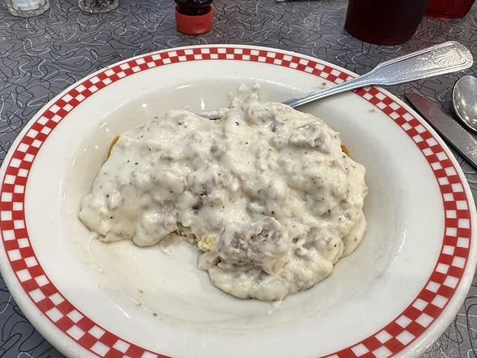 Biscuits and gravy so decadent they should require a permission slip &ndash; creamy, peppery heaven on a red-checkered plate.