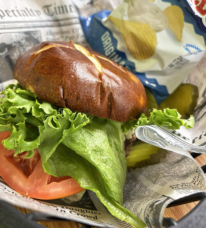 Fresh lettuce and tomato try valiantly to make this indulgence seem healthy, but that glistening burger knows better. Resistance is futile.