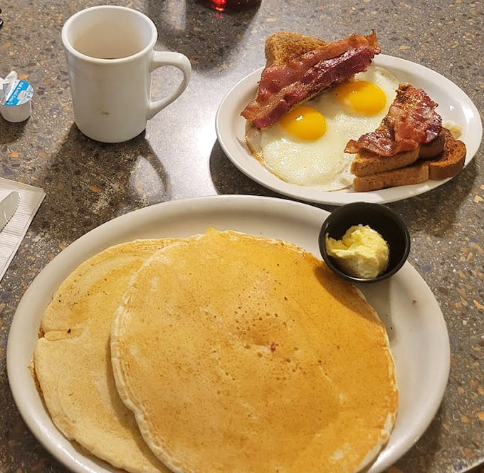The classic American breakfast in all its glory &ndash; sunny-side eggs with that perfect runny yolk, crispy bacon, and toast waiting for butter.