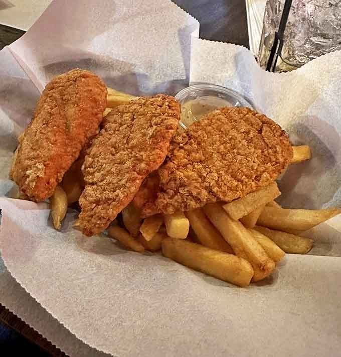 Golden-brown, hand-breaded chicken tenders rest atop a mountain of crispy fries &ndash; comfort food that satisfies without pretension.