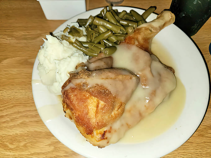 Half a chicken, perfectly roasted with crispy skin, nestled alongside creamy mashed potatoes and vibrant green beans &ndash; simple perfection.