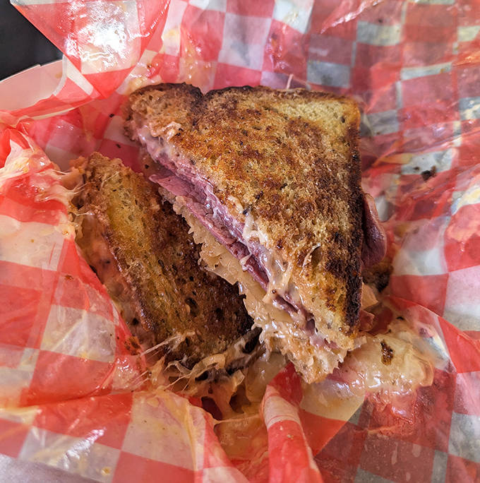 The classic Reuben reveals its secrets: perfectly grilled rye bread giving way to layers of tender corned beef and tangy sauerkraut in perfect harmony.
