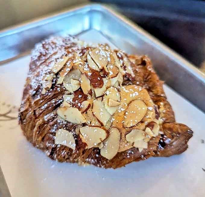 The almond croissant wears its sliced nut topping like a crown, hiding a frangipane treasure within that would make French royalty weep.