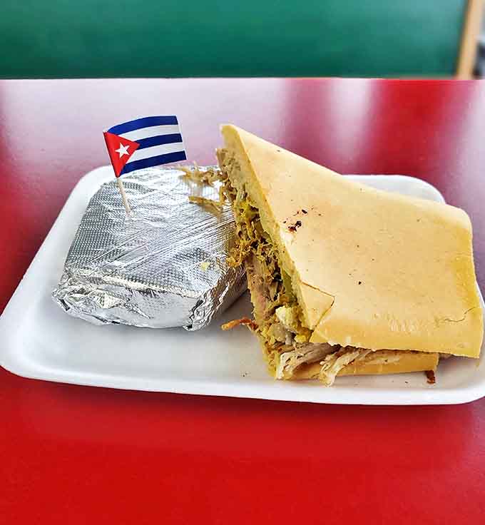 The Cuban sandwich arrives with its own tiny flag, as if to say, "I'm not just food, I'm an international incident of deliciousness."