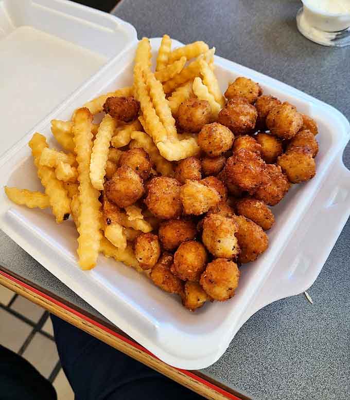 Popcorn chicken and crinkle-cut fries piled high on a plate, proving that sometimes the simplest combinations are the most satisfying.
