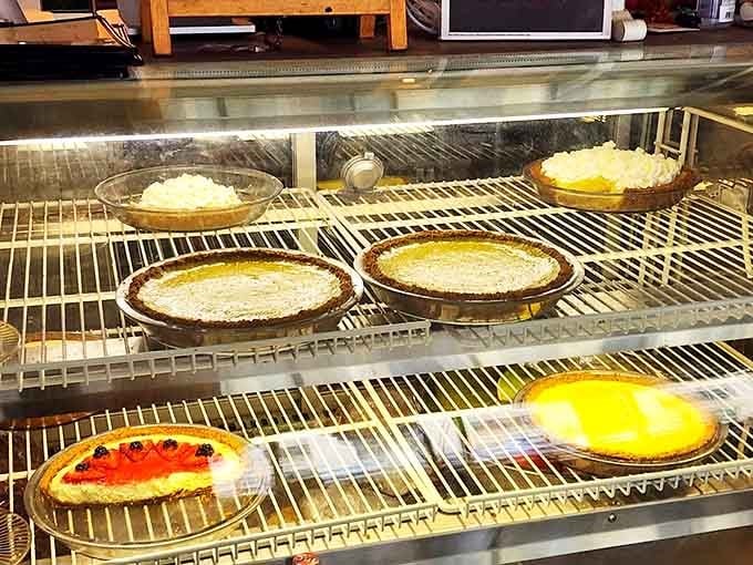 The refrigerated display case reveals a rainbow of pie possibilities &ndash; from creamy custards to fruit-filled wonders waiting for your fork.