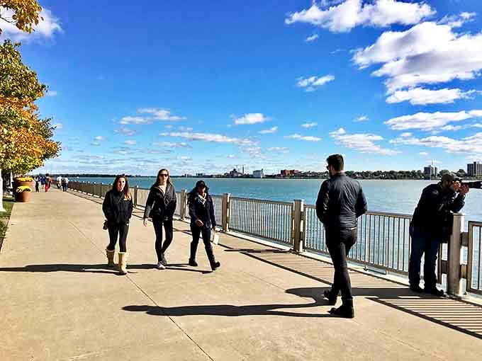 Strollers enjoying the RiverWalk's perfect blend of urban energy and waterfront tranquility, where every step offers a new perspective on Motor City.